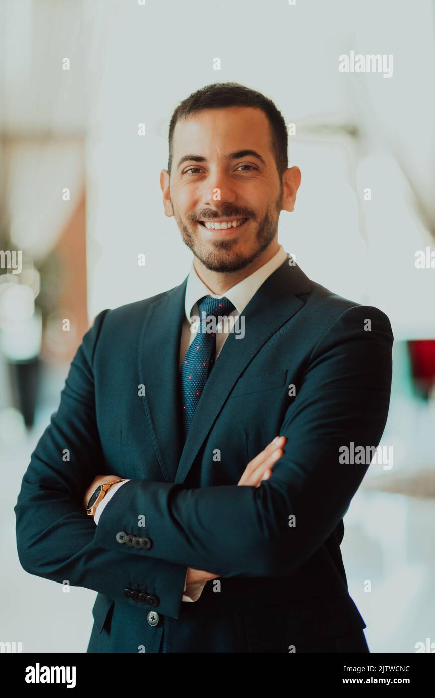 Portrait of a businessman in a suit with his arms crossed in a modern ...