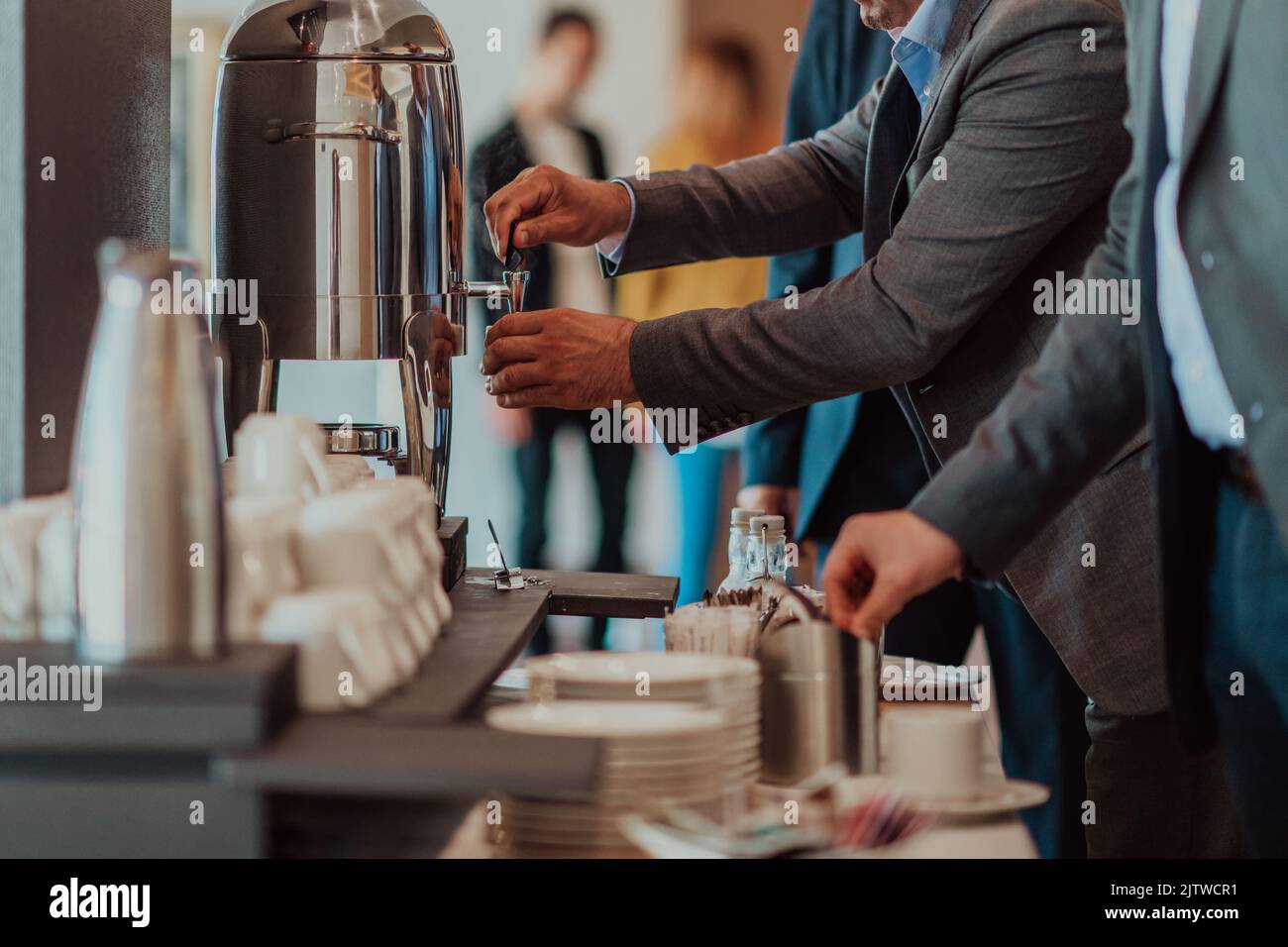 Close-up photo of businessmen serving themselves in a modern hotel ...