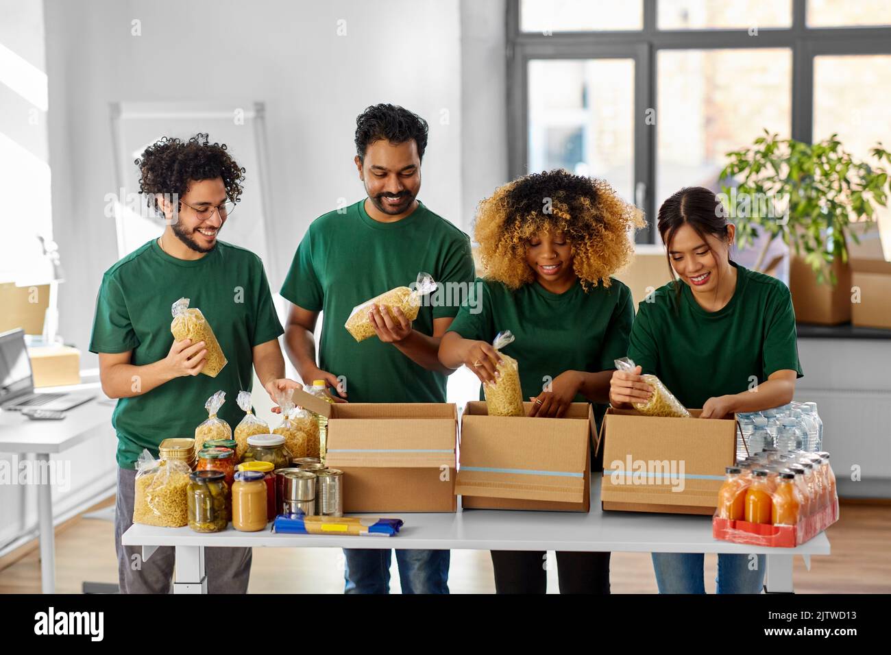 happy volunteers packing food in donation boxes Stock Photo - Alamy
