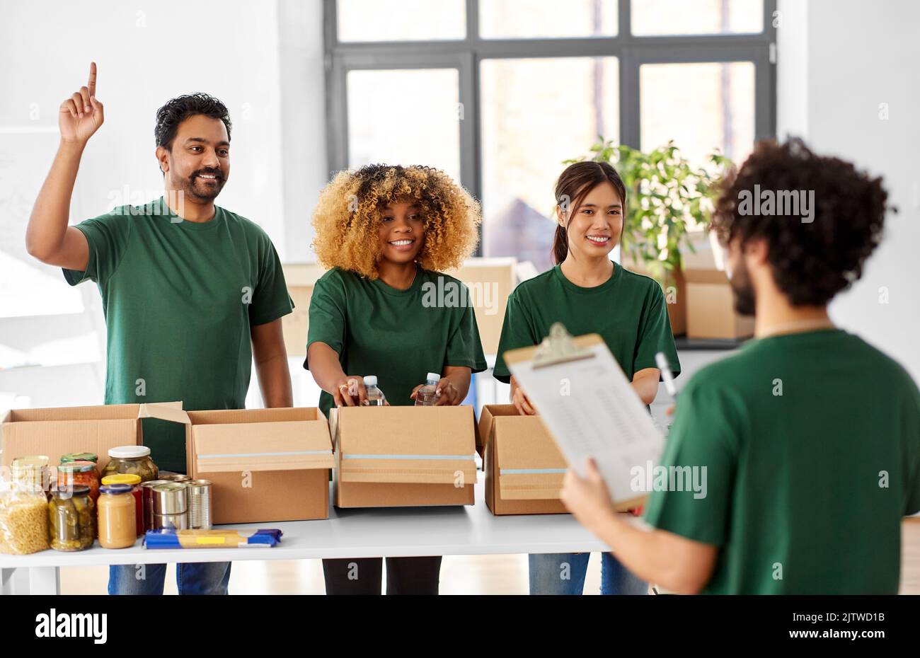 happy volunteers packing food in donation boxes Stock Photo - Alamy