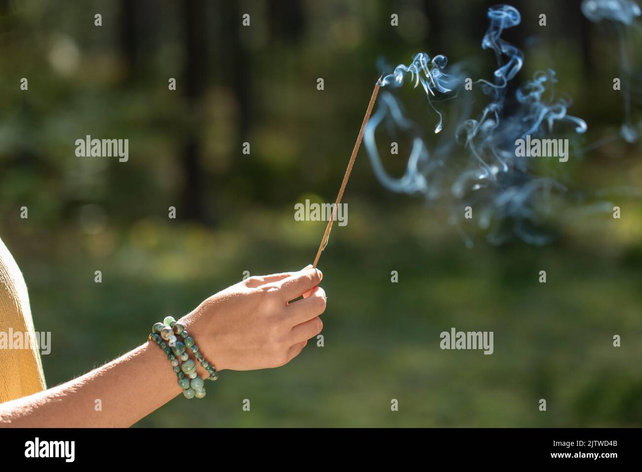 hand with smoking incense stick in forest Stock Photo - Alamy