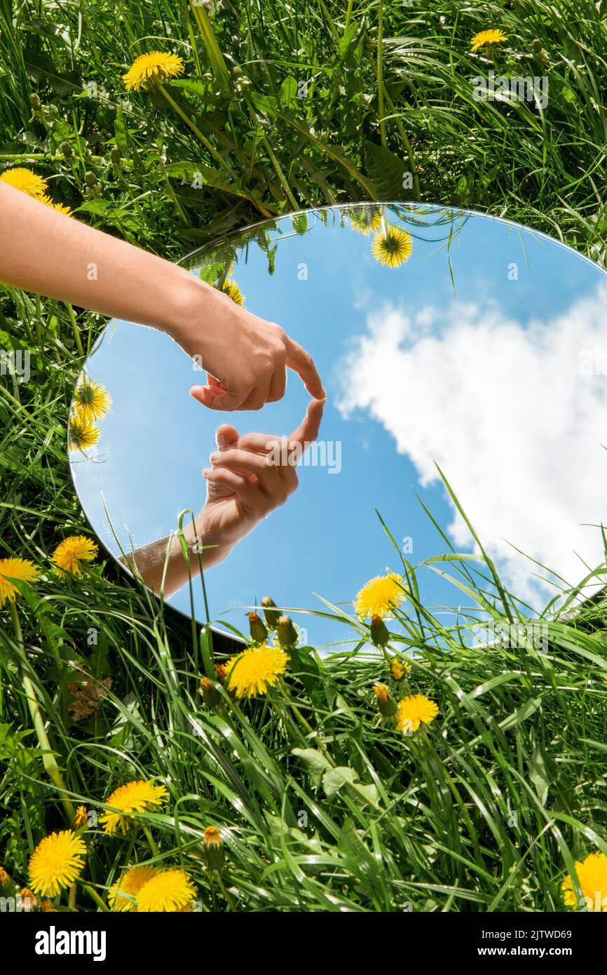 hand touching sky reflection in mirror on field Stock Photo - Alamy