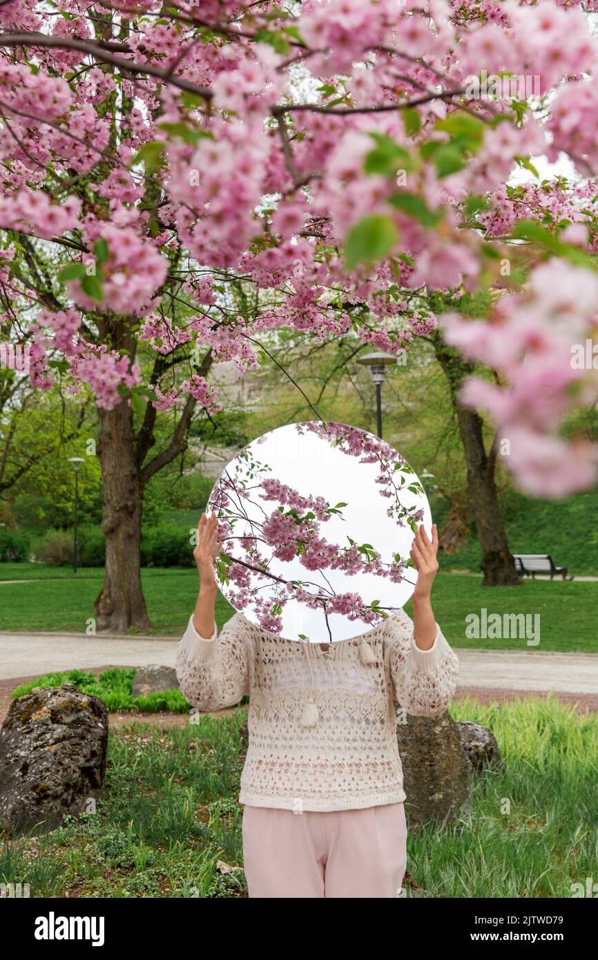 woman with cherry tree reflection in round mirror Stock Photo - Alamy