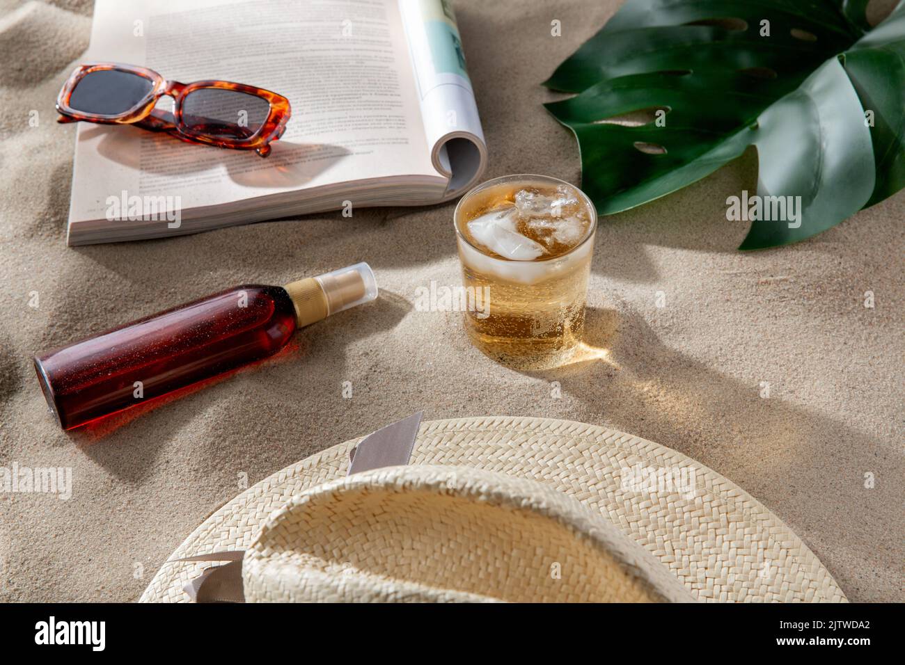 magazine, sunglasses and sunscreen on beach sand Stock Photo - Alamy