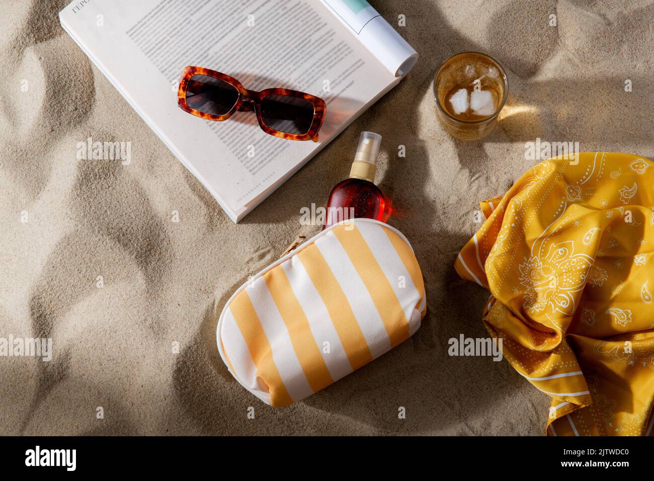 magazine, sunglasses and sunscreen on beach sand Stock Photo - Alamy