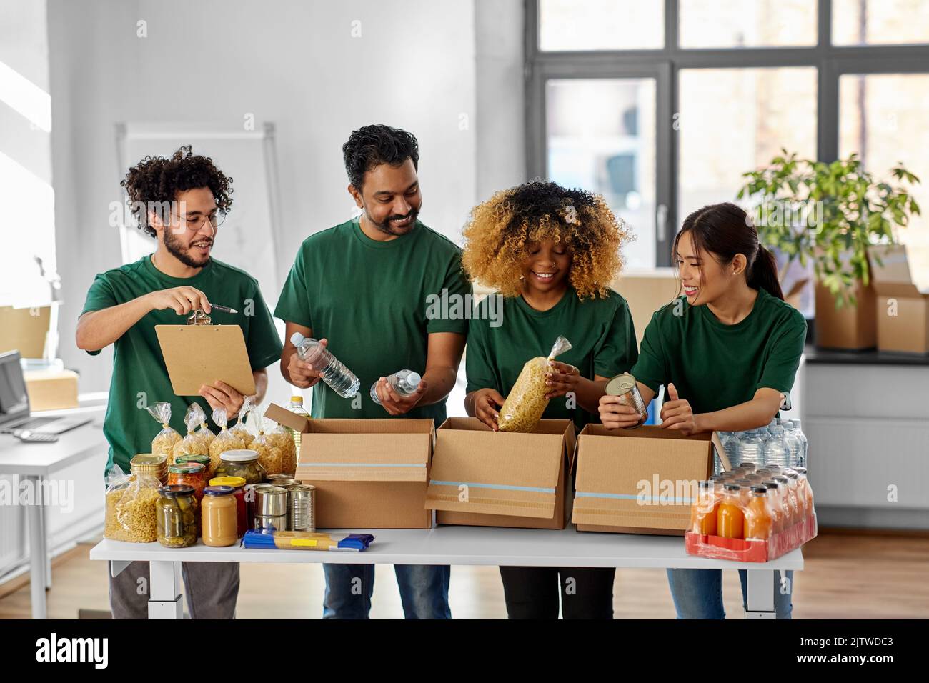 happy volunteers packing food in donation boxes Stock Photo - Alamy