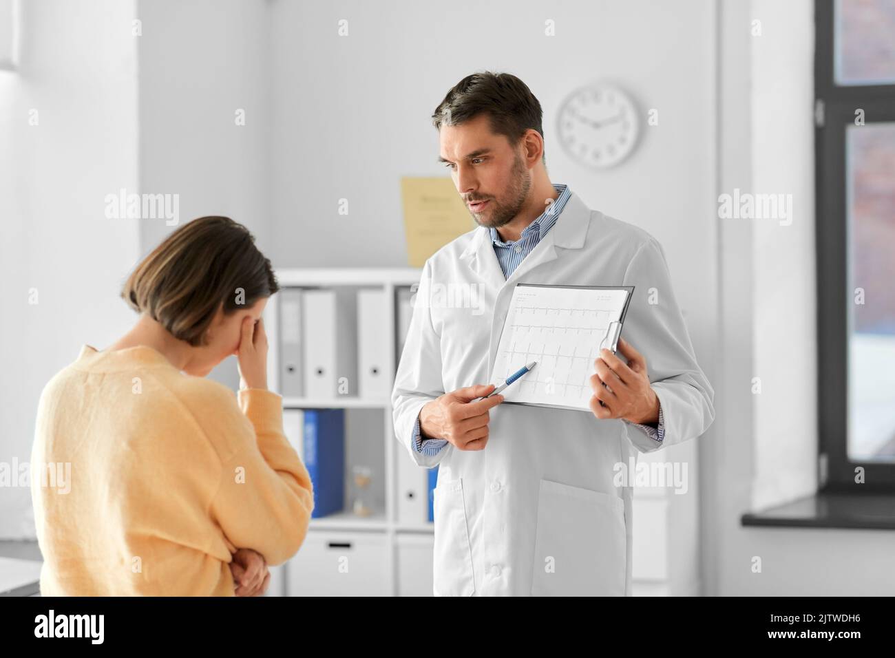 doctor showing cardiogram to sad woman at hospital Stock Photo - Alamy
