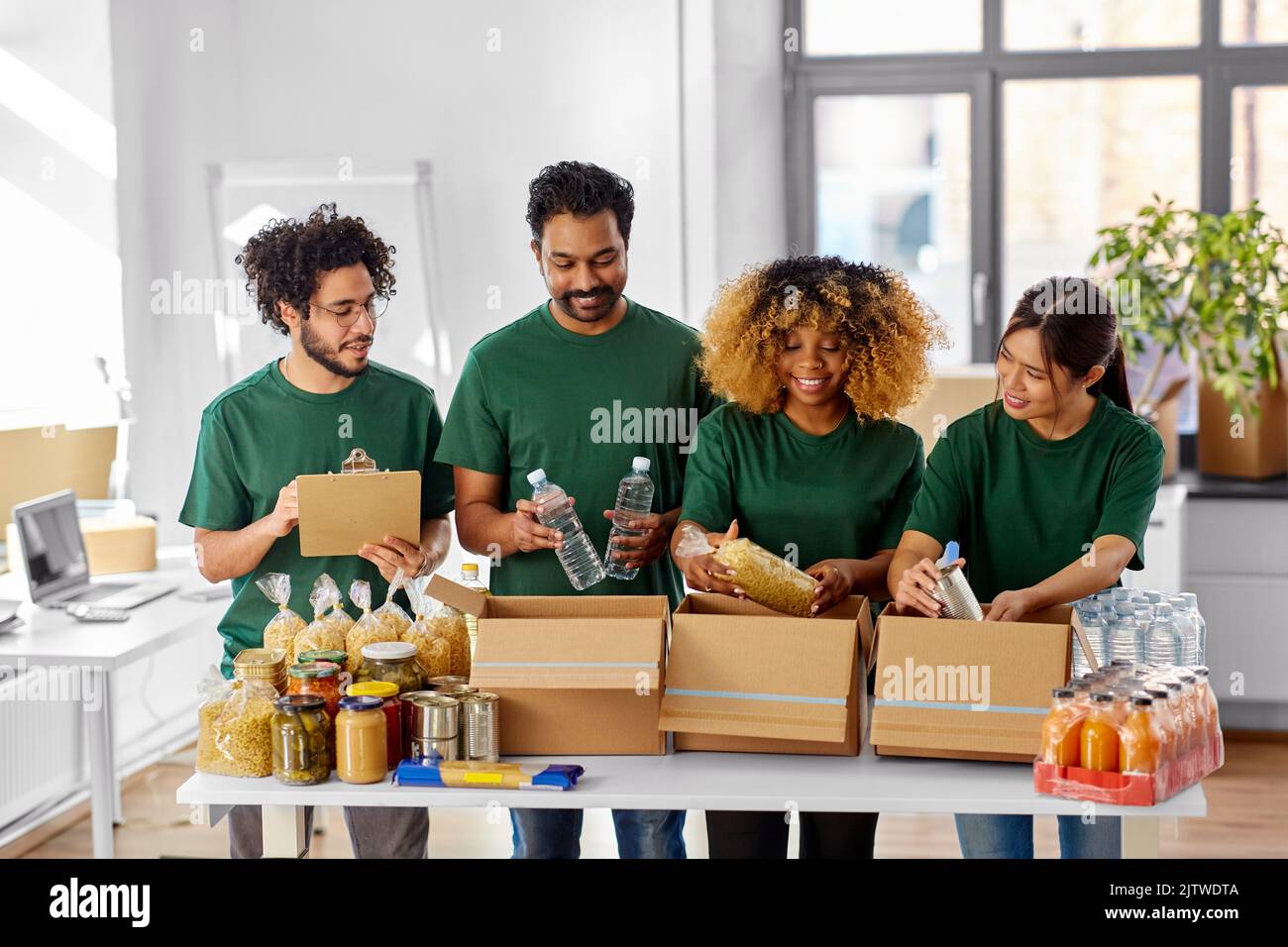happy volunteers packing food in donation boxes Stock Photo - Alamy