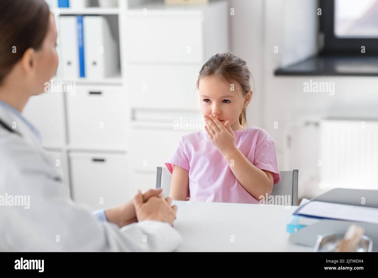 doctor and little girl patient coughing at clinic Stock Photo - Alamy