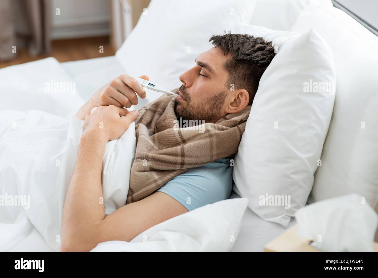 sick man measuring temperature by thermometer Stock Photo - Alamy