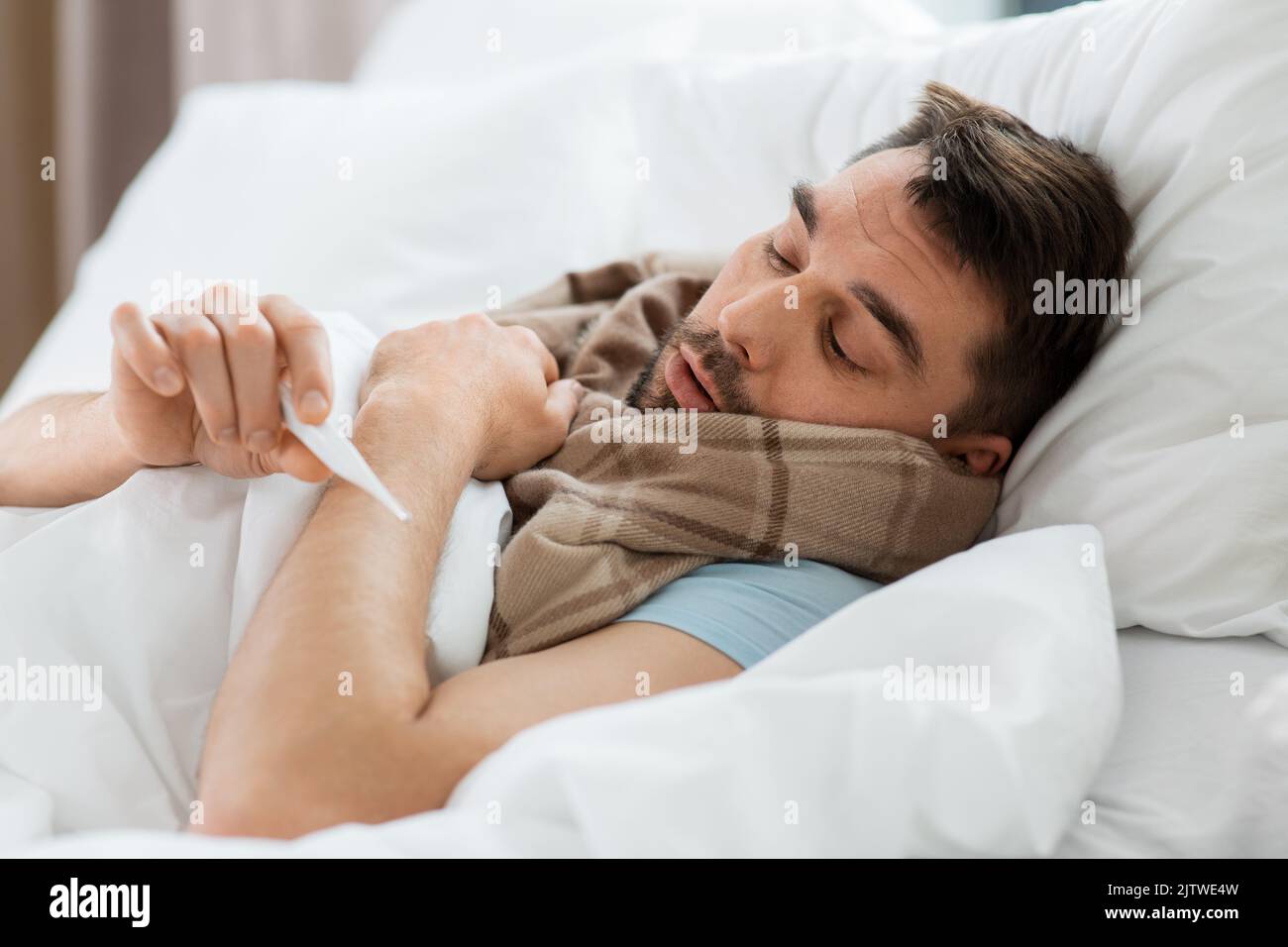 sick man measuring temperature by thermometer Stock Photo - Alamy