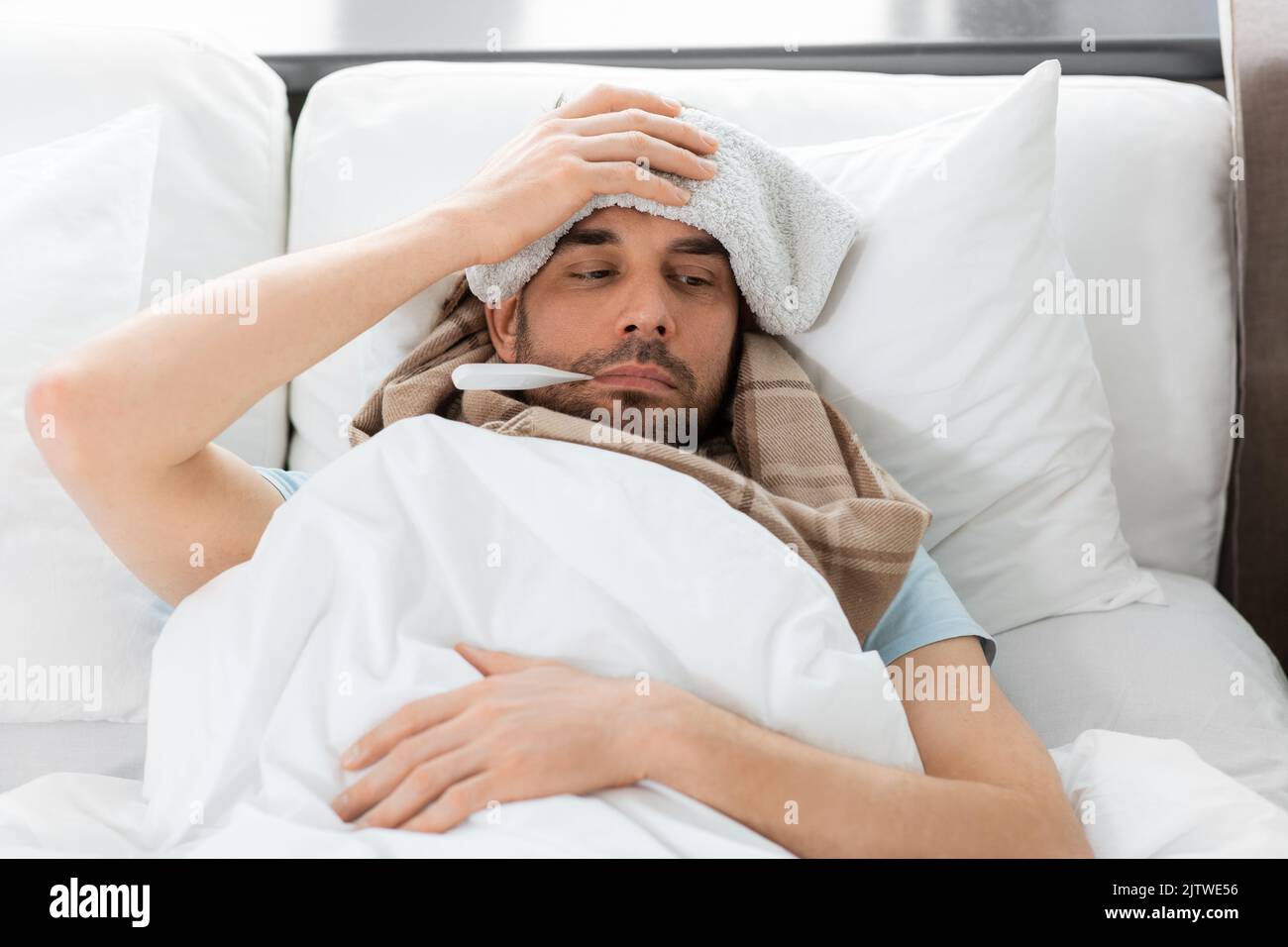 sick man measuring temperature by thermometer Stock Photo - Alamy