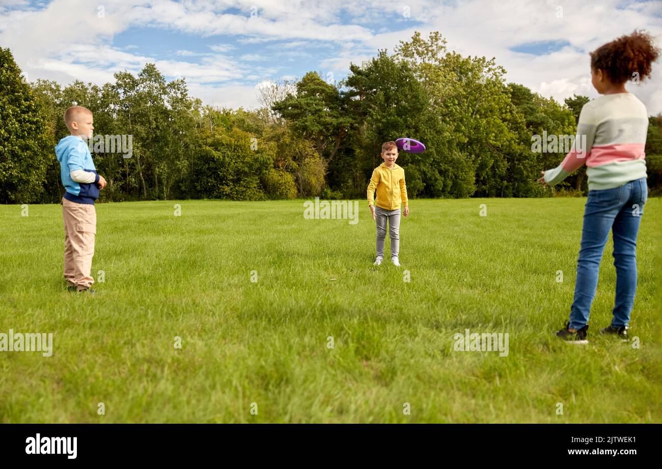 happy children playing with flying disc at park Stock Photo - Alamy