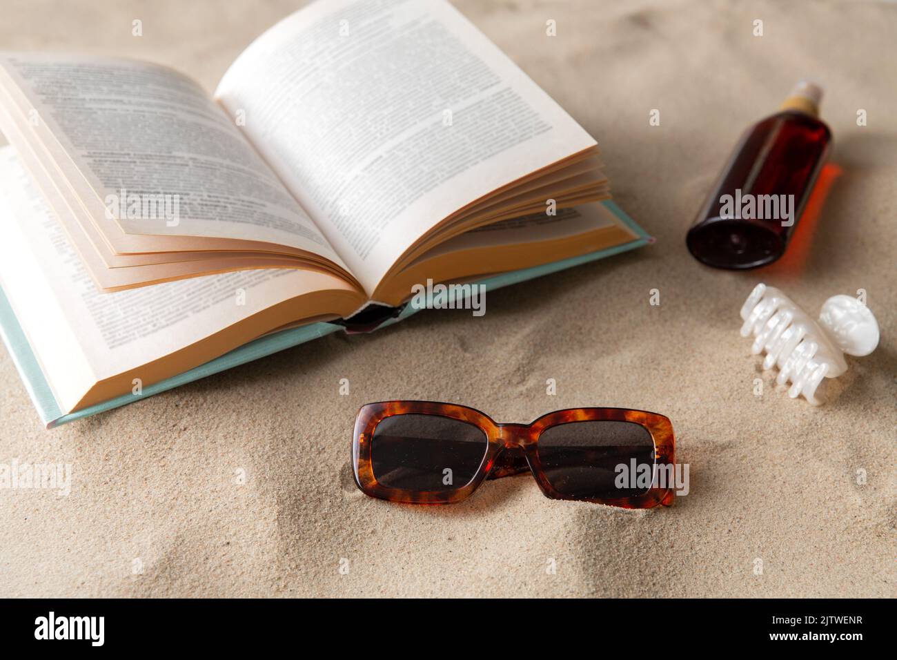book, sunglasses and sunscreen on beach sand Stock Photo - Alamy