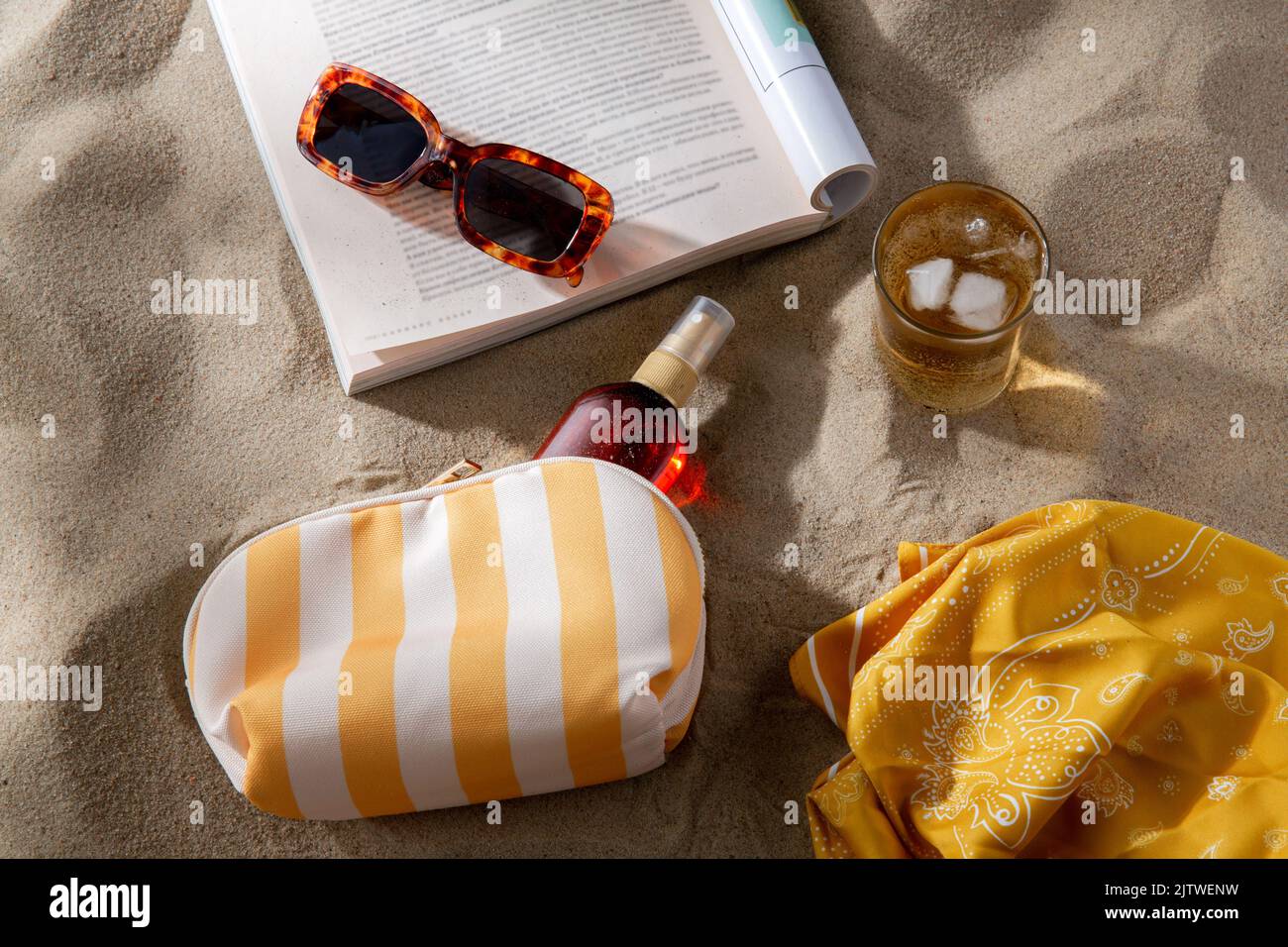 magazine, sunglasses and sunscreen on beach sand Stock Photo - Alamy