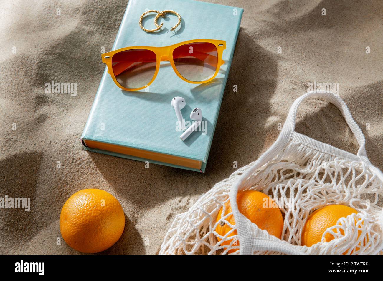 bag of oranges, earbuds and sunglasses on beach Stock Photo - Alamy