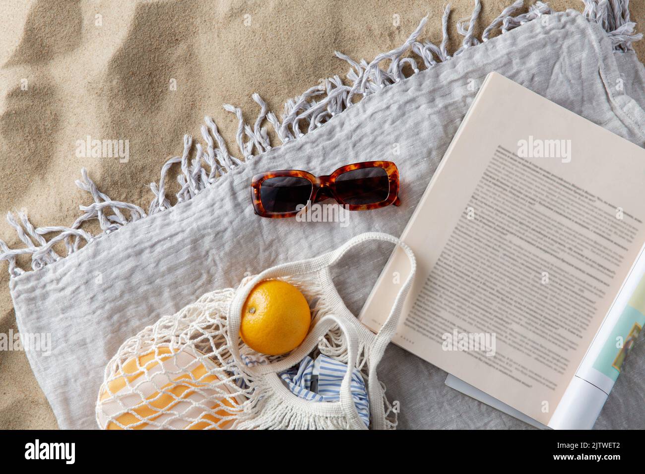 bag of oranges, sunglasses and magazine on beach Stock Photo - Alamy