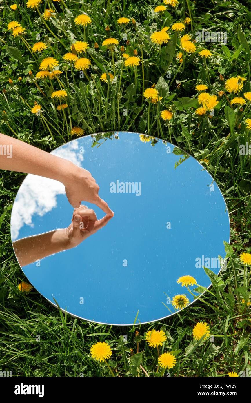 hand touching sky reflection in mirror on field Stock Photo - Alamy