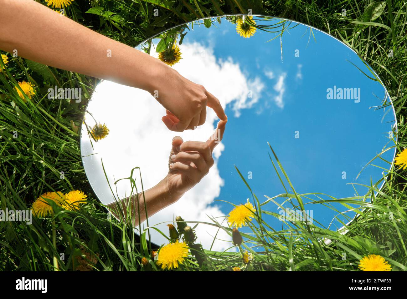 hand touching sky reflection in mirror on field Stock Photo - Alamy