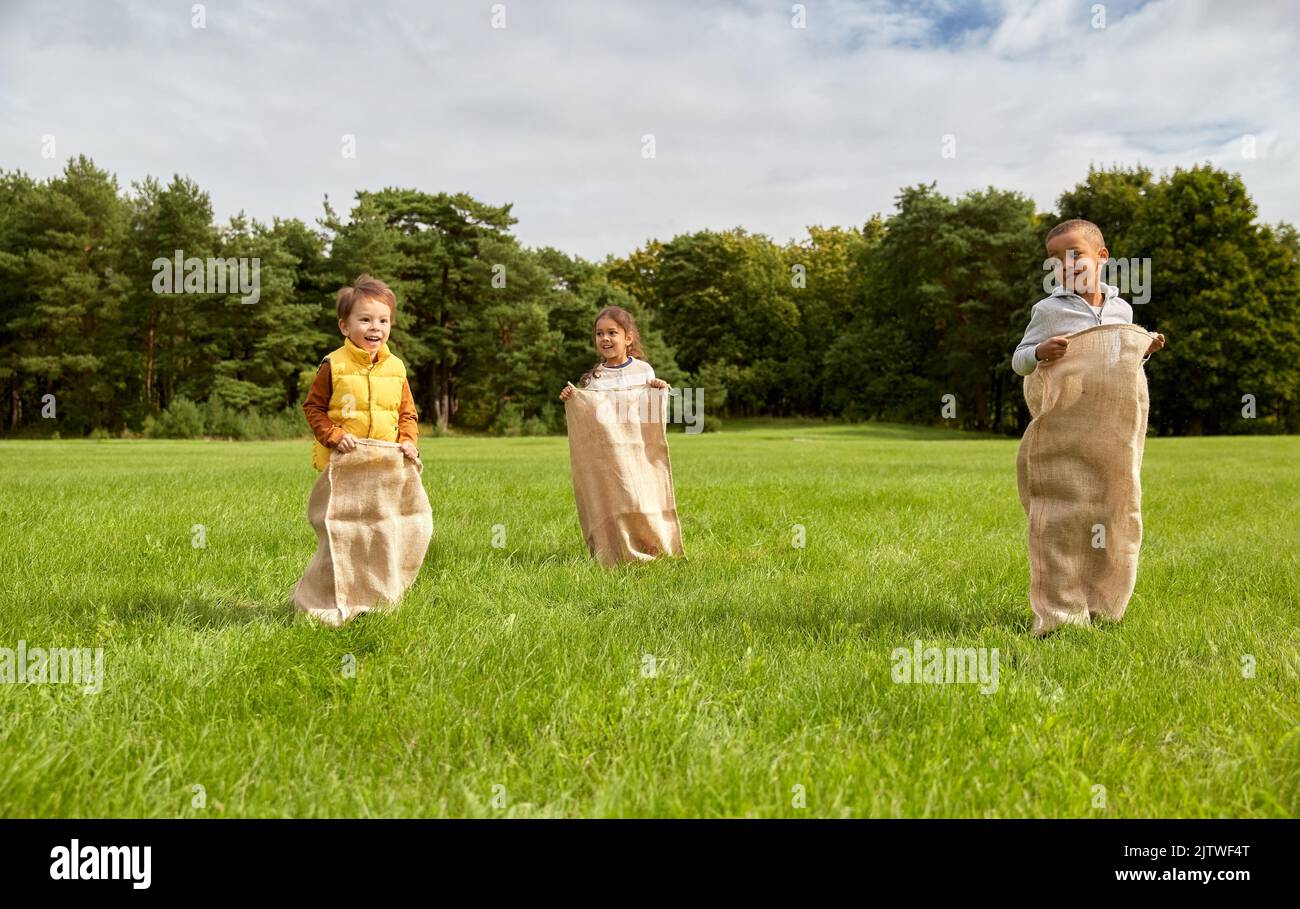 happy children playing bag jumping game at park Stock Photo - Alamy