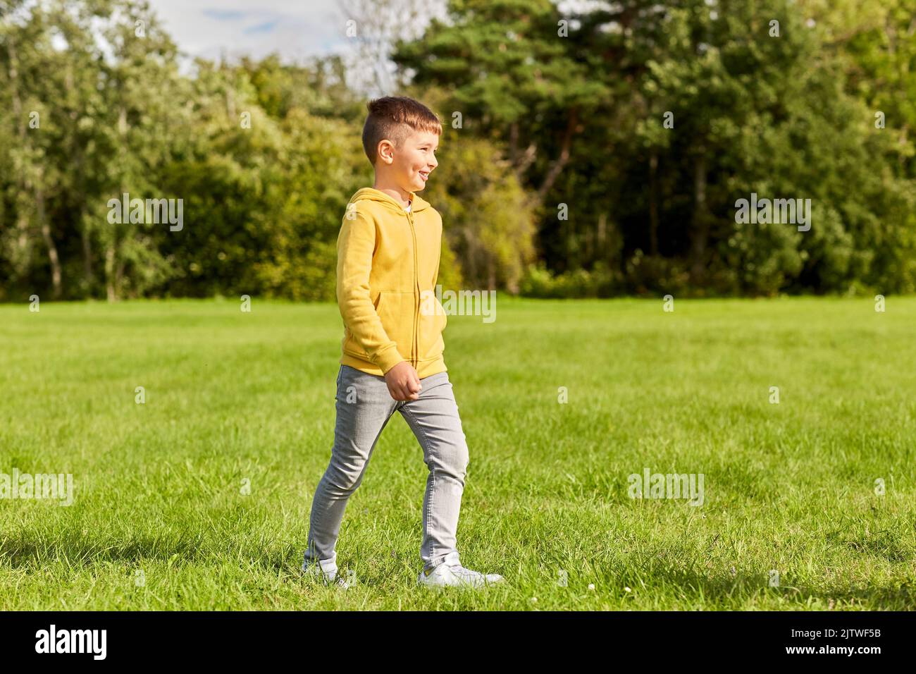 happy boy walking on lawn at park Stock Photo - Alamy