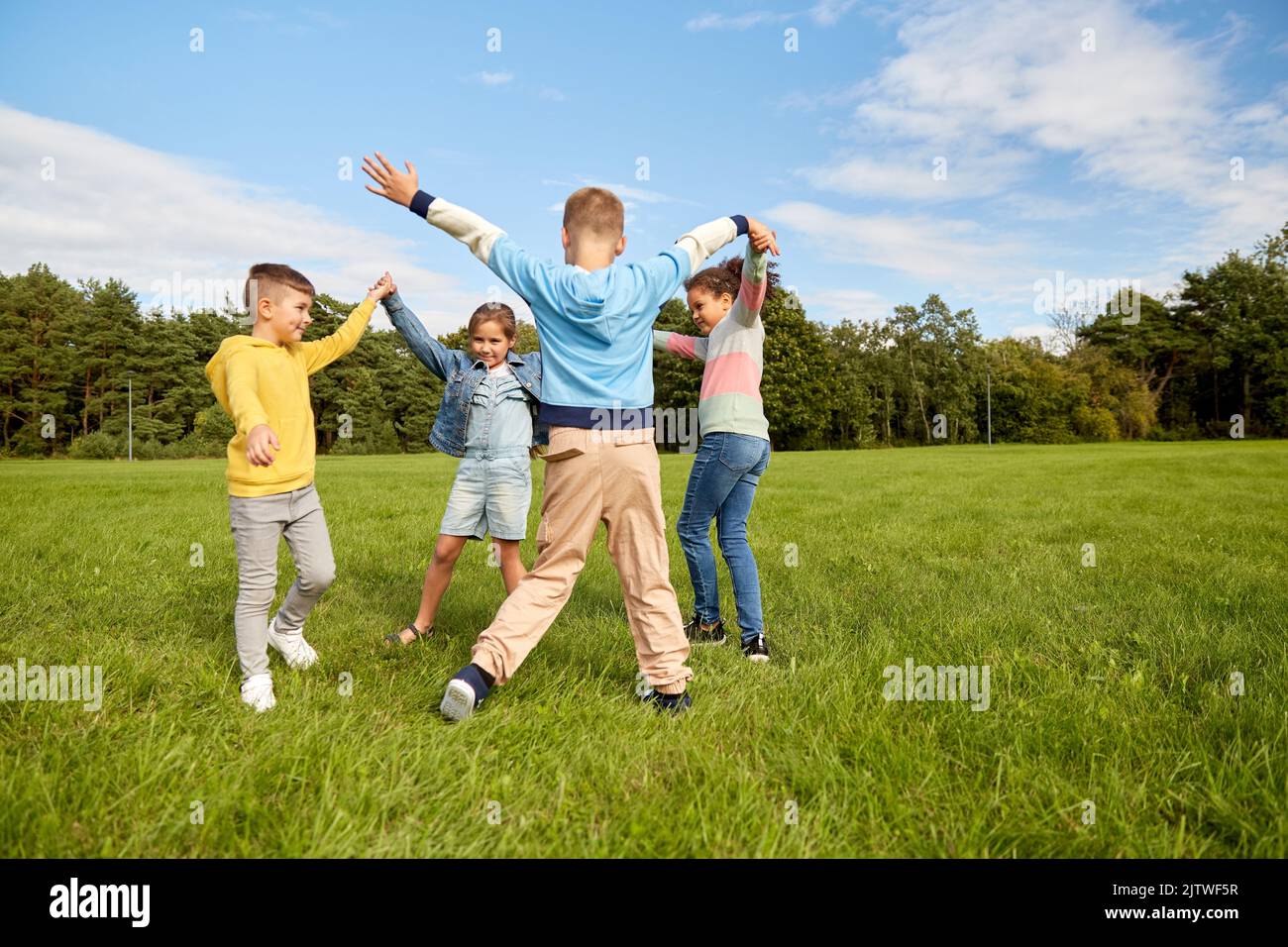 happy children playing round dance at park Stock Photo - Alamy
