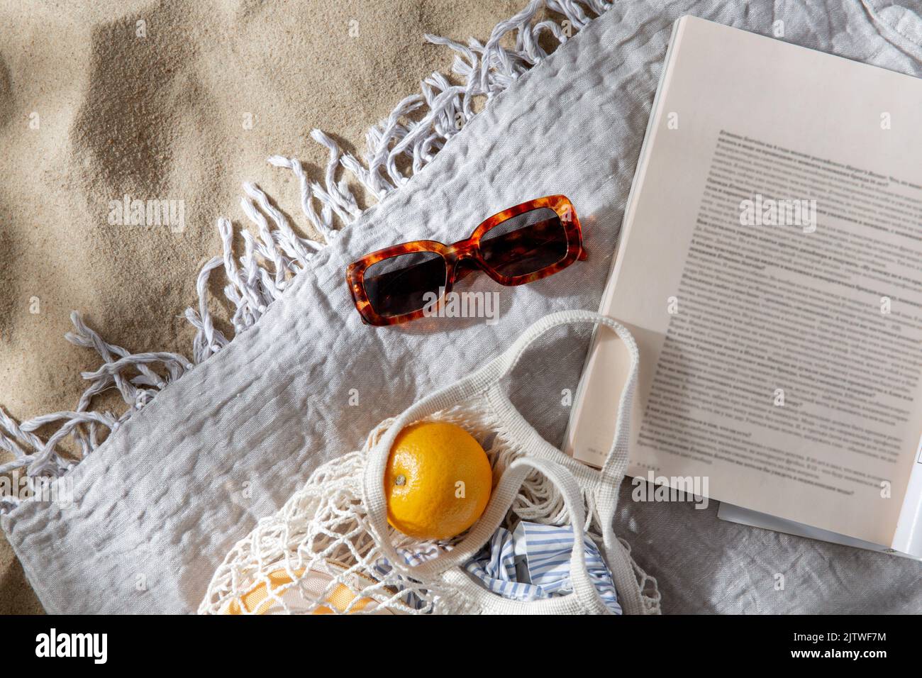 bag of oranges, sunglasses and magazine on beach Stock Photo - Alamy
