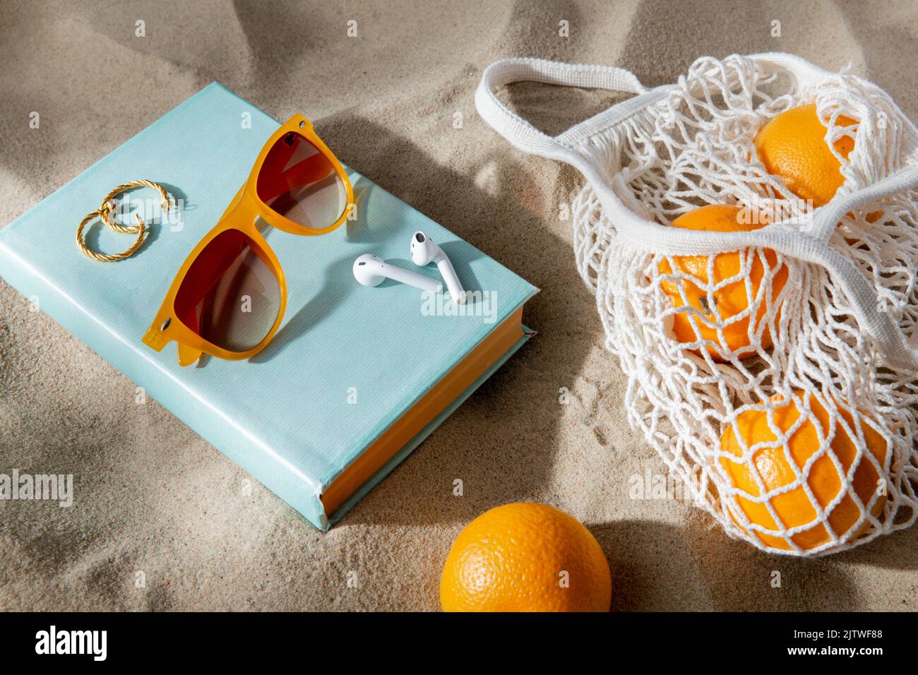 bag of oranges, earbuds and sunglasses on beach Stock Photo - Alamy
