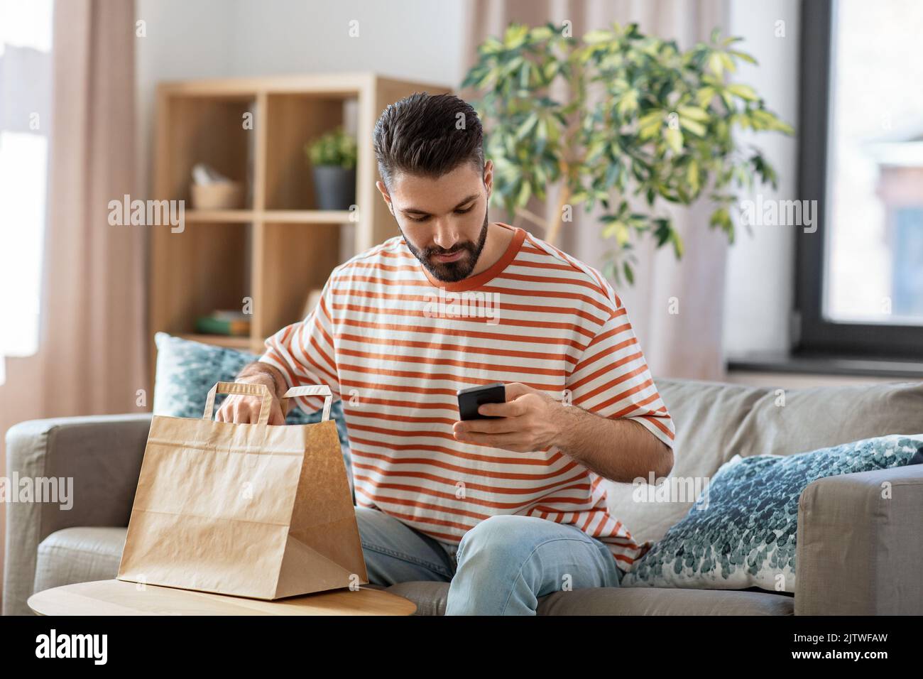 man with phone checking food order at home Stock Photo - Alamy