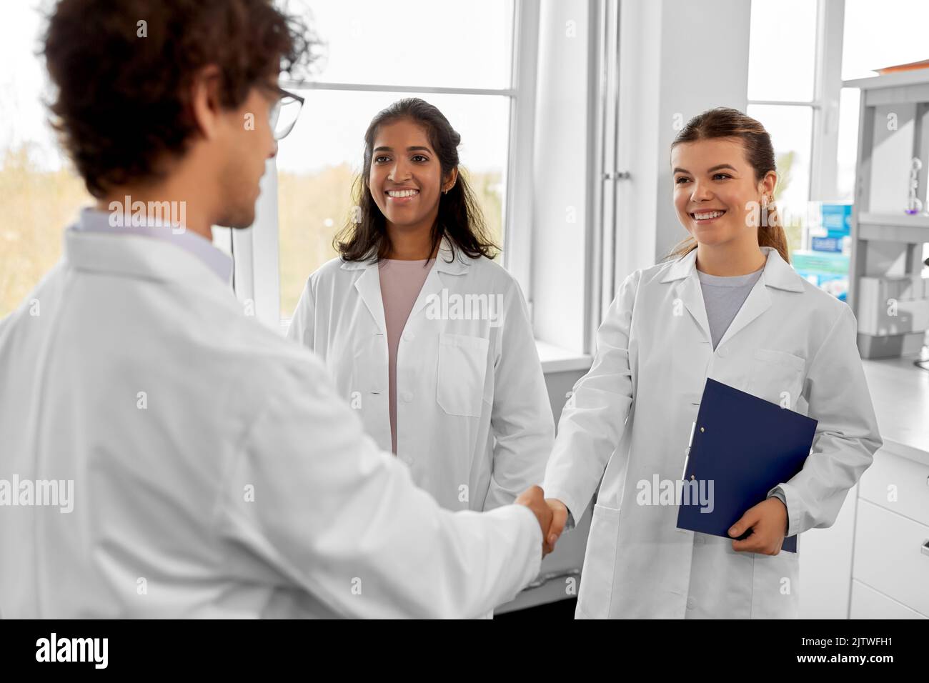scientists shaking hands in laboratory Stock Photo - Alamy
