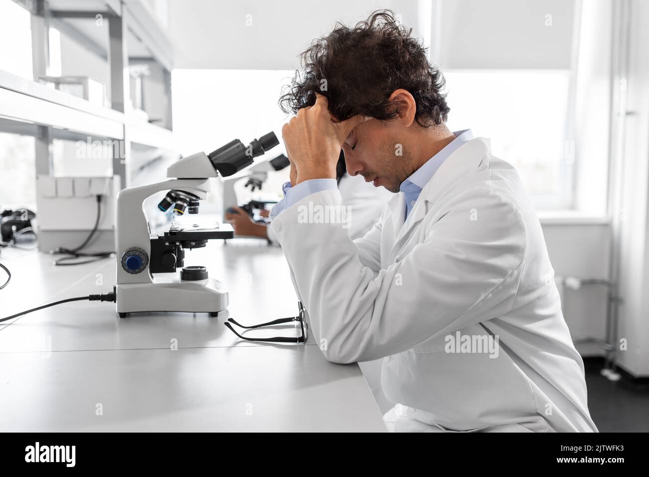 scientist with microscope working in laboratory Stock Photo - Alamy