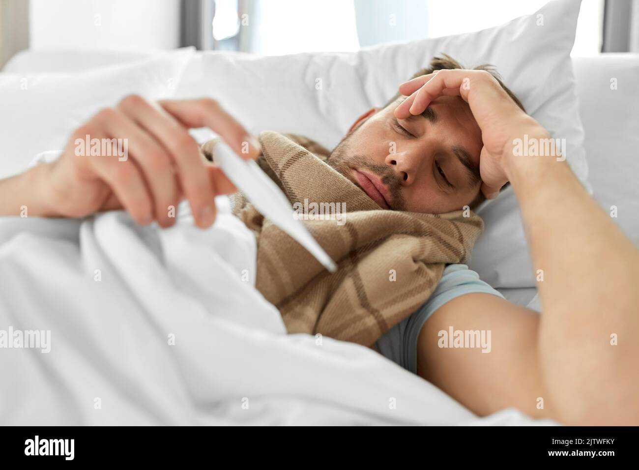 sick man measuring temperature by thermometer Stock Photo - Alamy
