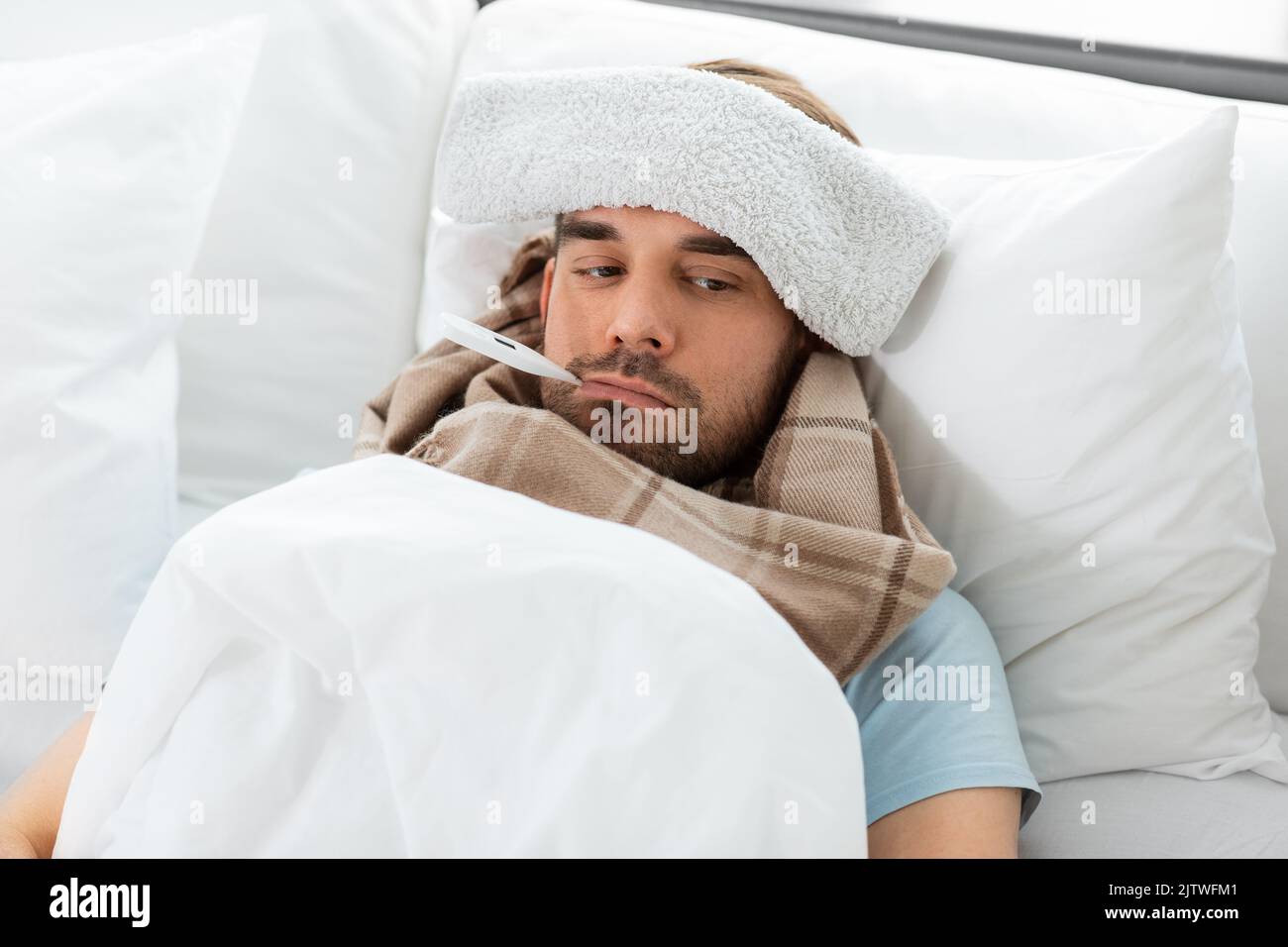 sick man measuring temperature by thermometer Stock Photo - Alamy