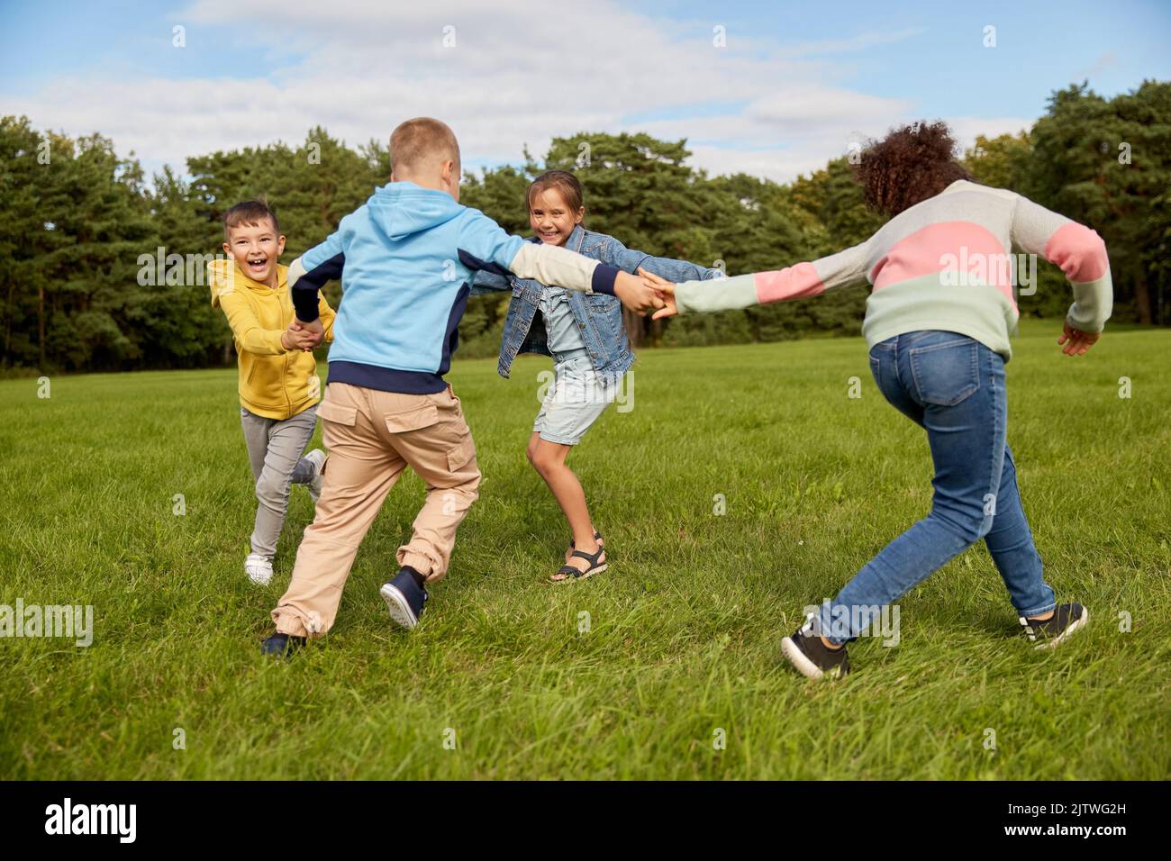 happy children playing round dance at park Stock Photo - Alamy