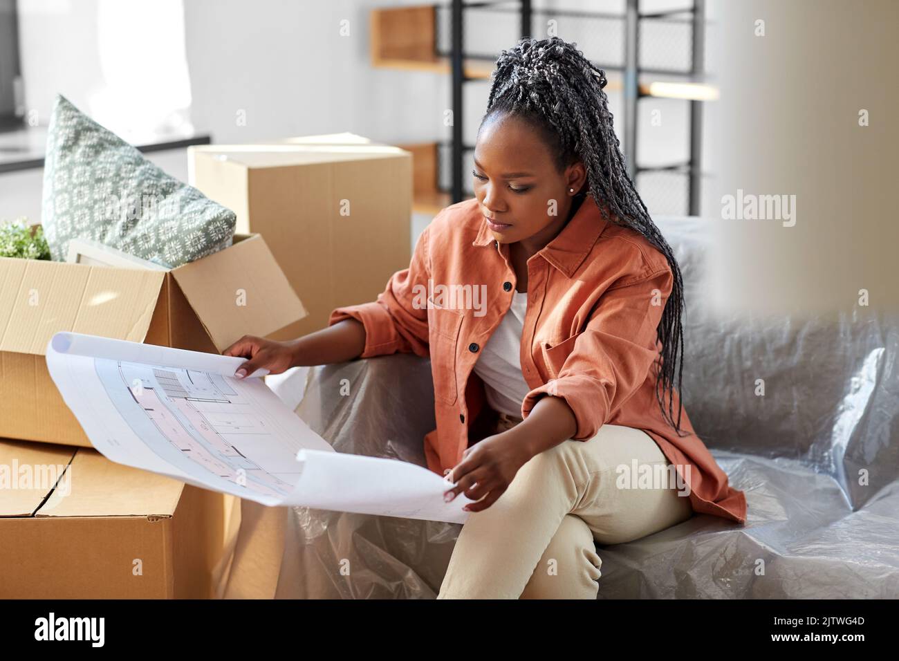 woman with blueprint and boxes moving to new home Stock Photo - Alamy