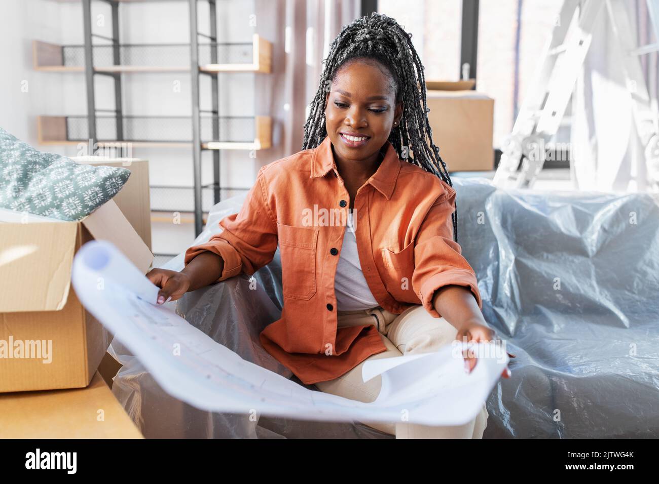 woman with blueprint and boxes moving to new home Stock Photo - Alamy