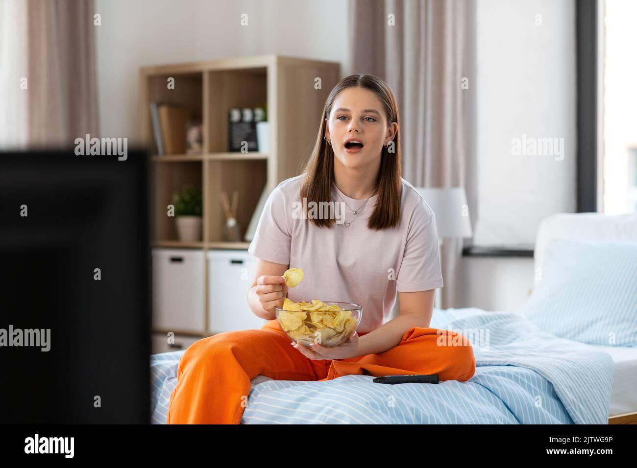 Girl child eating chips hi-res stock photography and images - Alamy