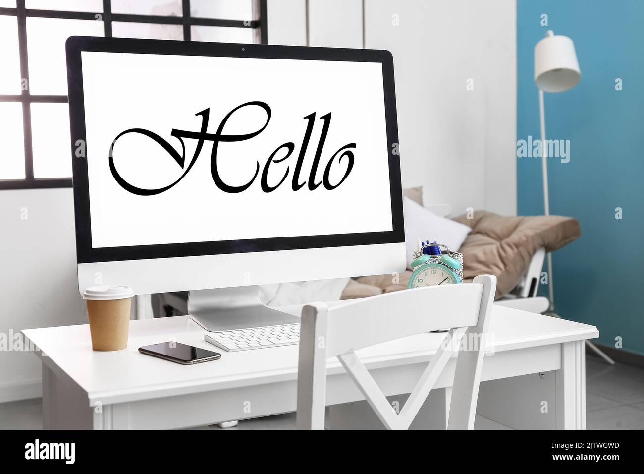 Modern computer with word HELLO on screen in room Stock Photo - Alamy
