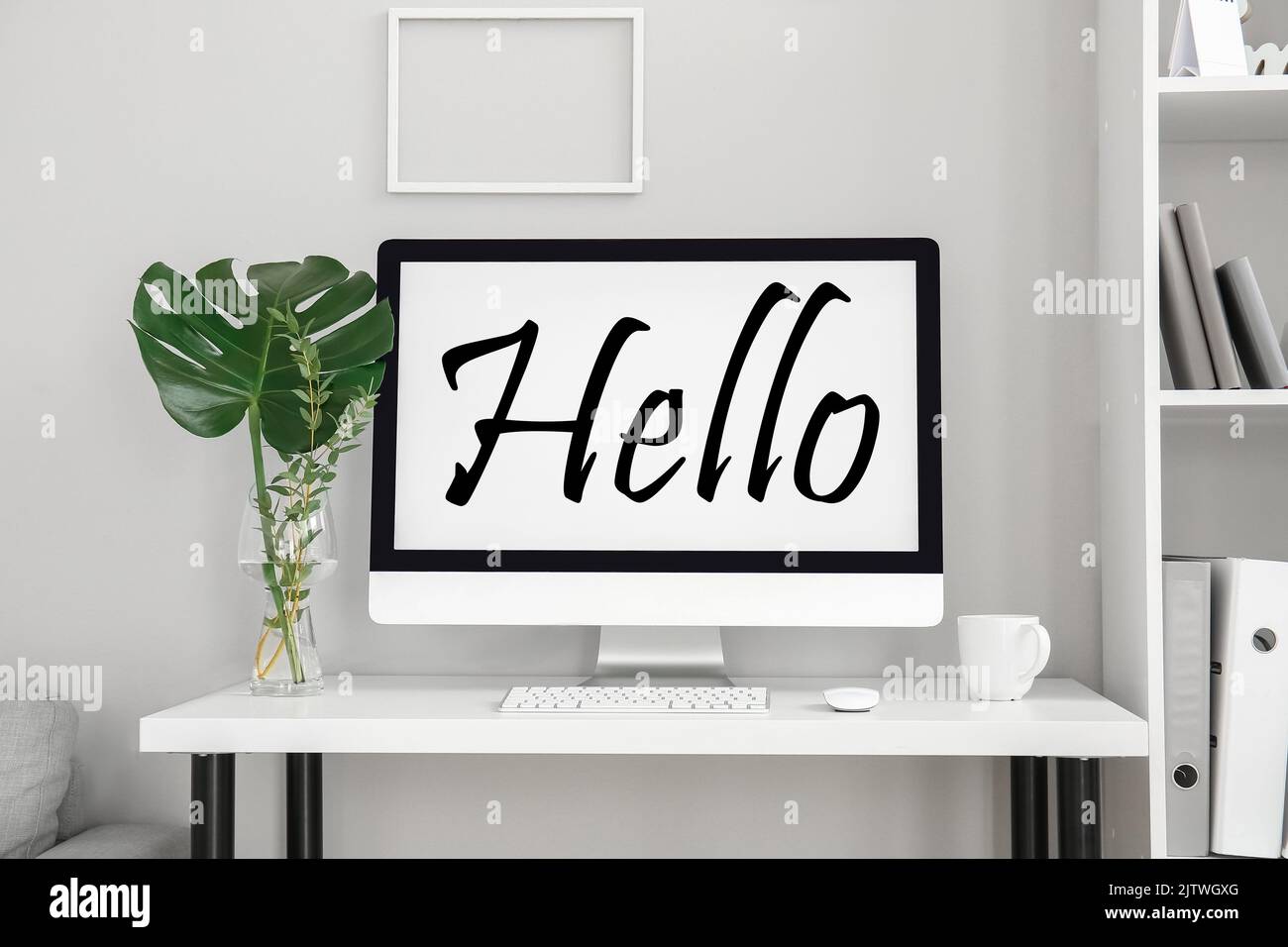 Modern computer with word HELLO on screen at workplace Stock Photo - Alamy