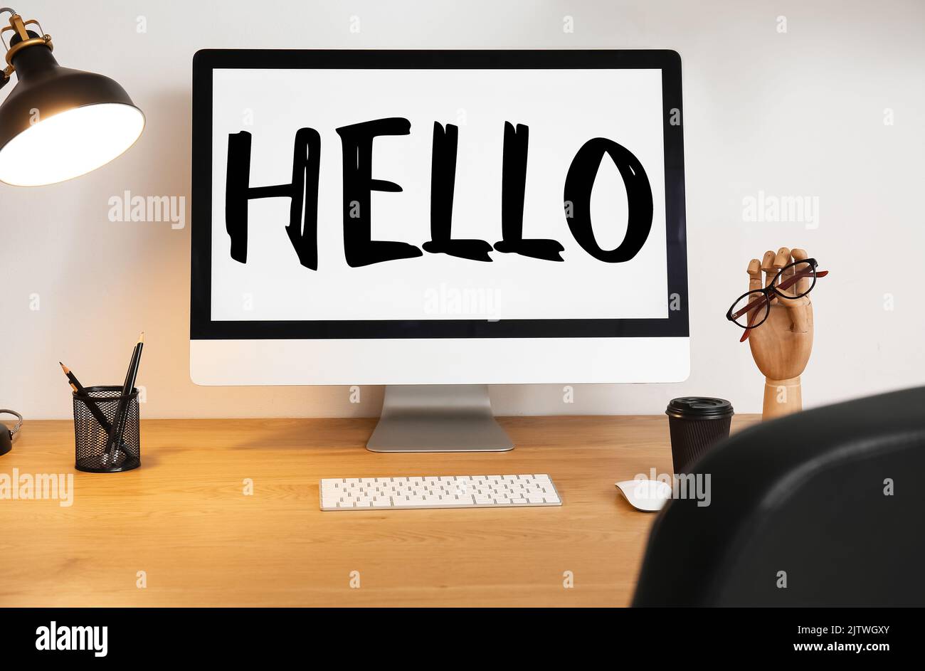 Modern computer with word HELLO on screen at workplace Stock Photo - Alamy