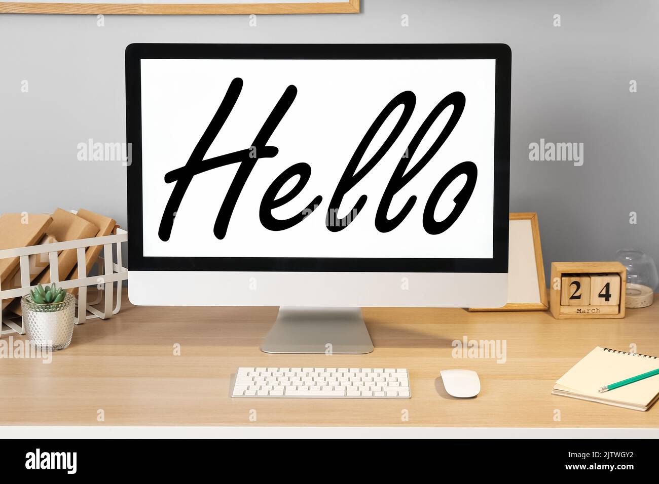 Modern computer with word HELLO on screen in room Stock Photo - Alamy