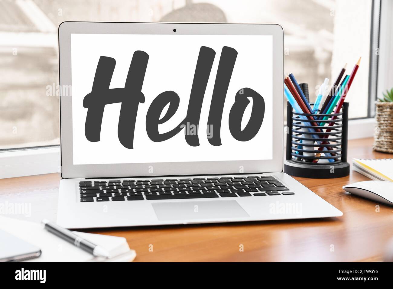 Modern laptop with word HELLO on screen in office Stock Photo - Alamy