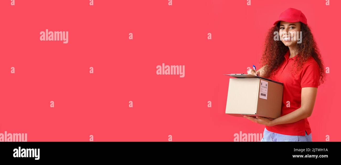 Female African-American courier with parcel on red background with ...