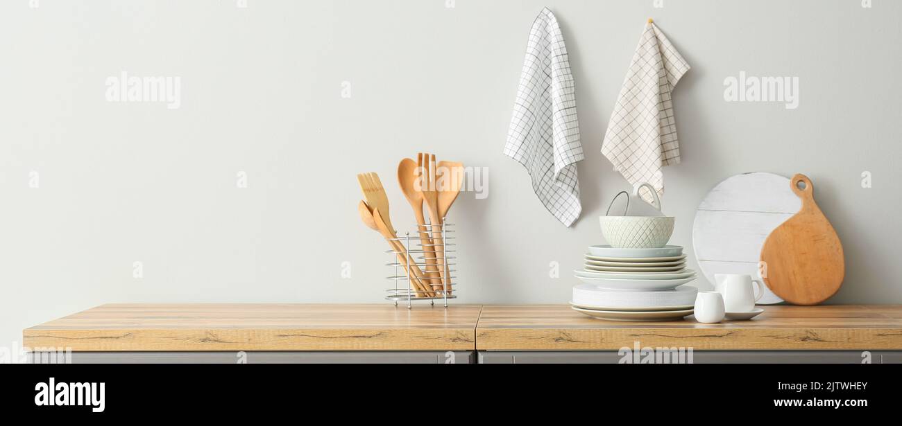 Interior of stylish kitchen with utensils and dinnerware on counter ...