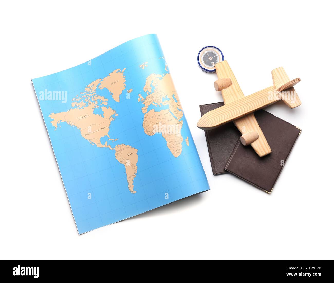 World map, compass, wooden airplane and passports isolated on white ...