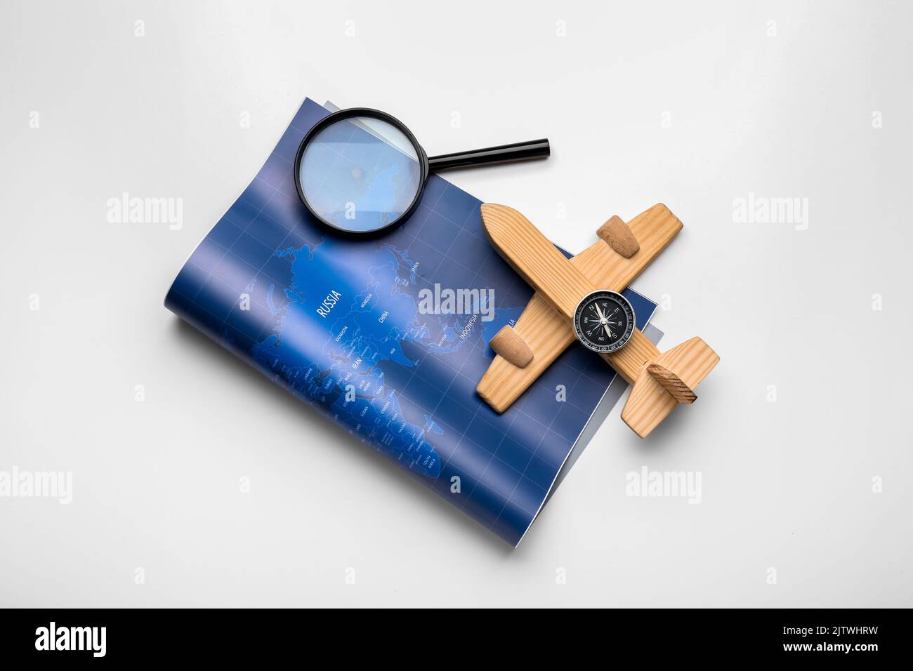 World map, wooden airplane, compass and magnifying glass isolated on ...