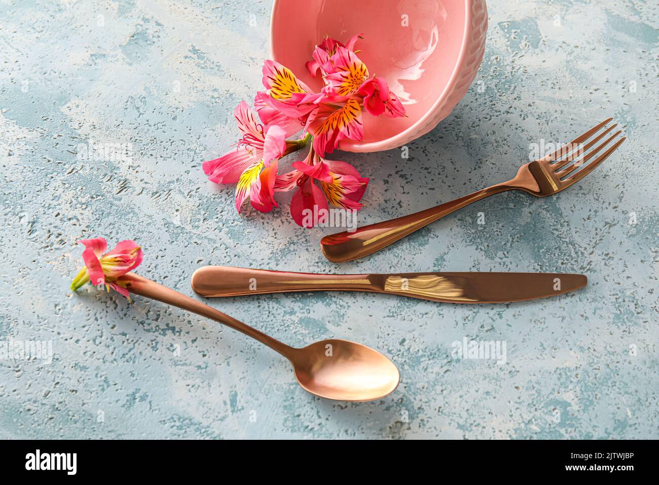 Table setting with beautiful alstroemeria flowers on blue background ...