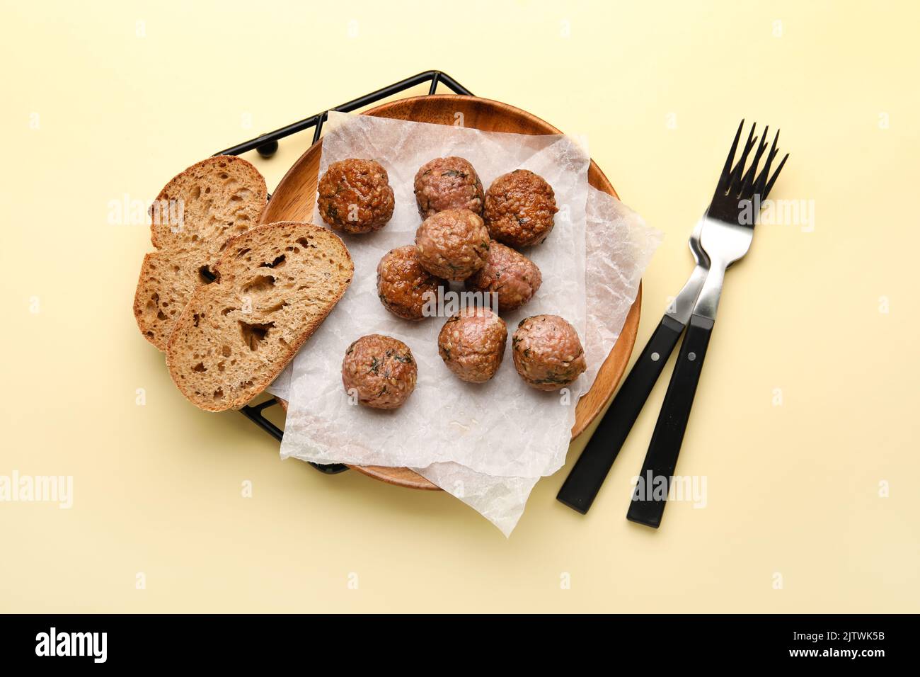 Stand with plate, meat balls, baking paper, forks and bread slice on ...