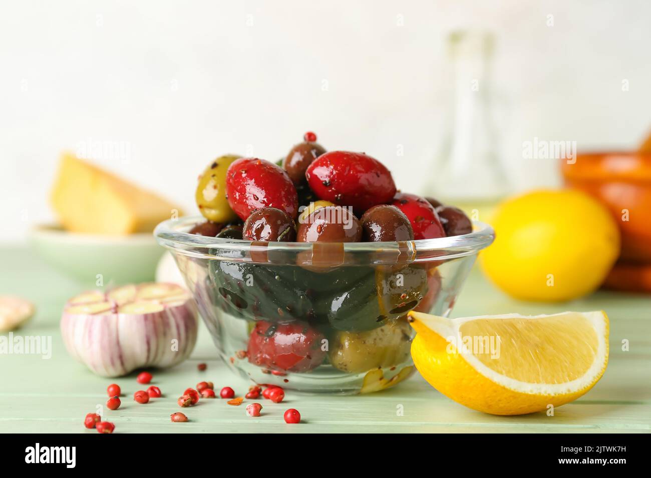 Glass bowl of delicious olives with spices on table Stock Photo - Alamy