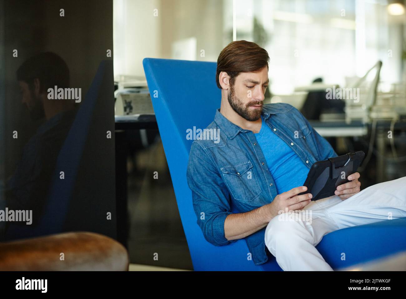 Taking an online break in the office. a young businessman using a ...